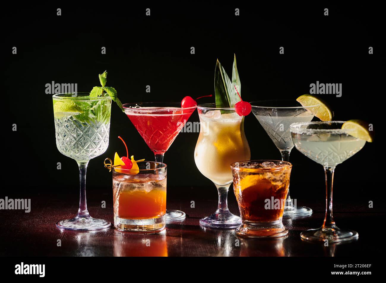 set of different sophisticated cocktails with fresh garnishing on black ...