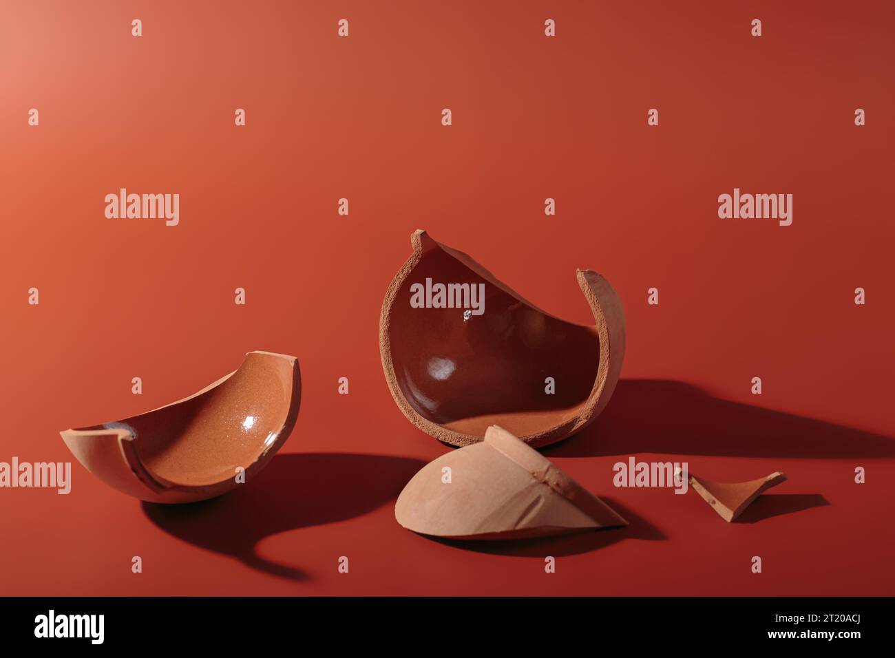 Details of broken ceramic cup on red background Stock Photo - Alamy