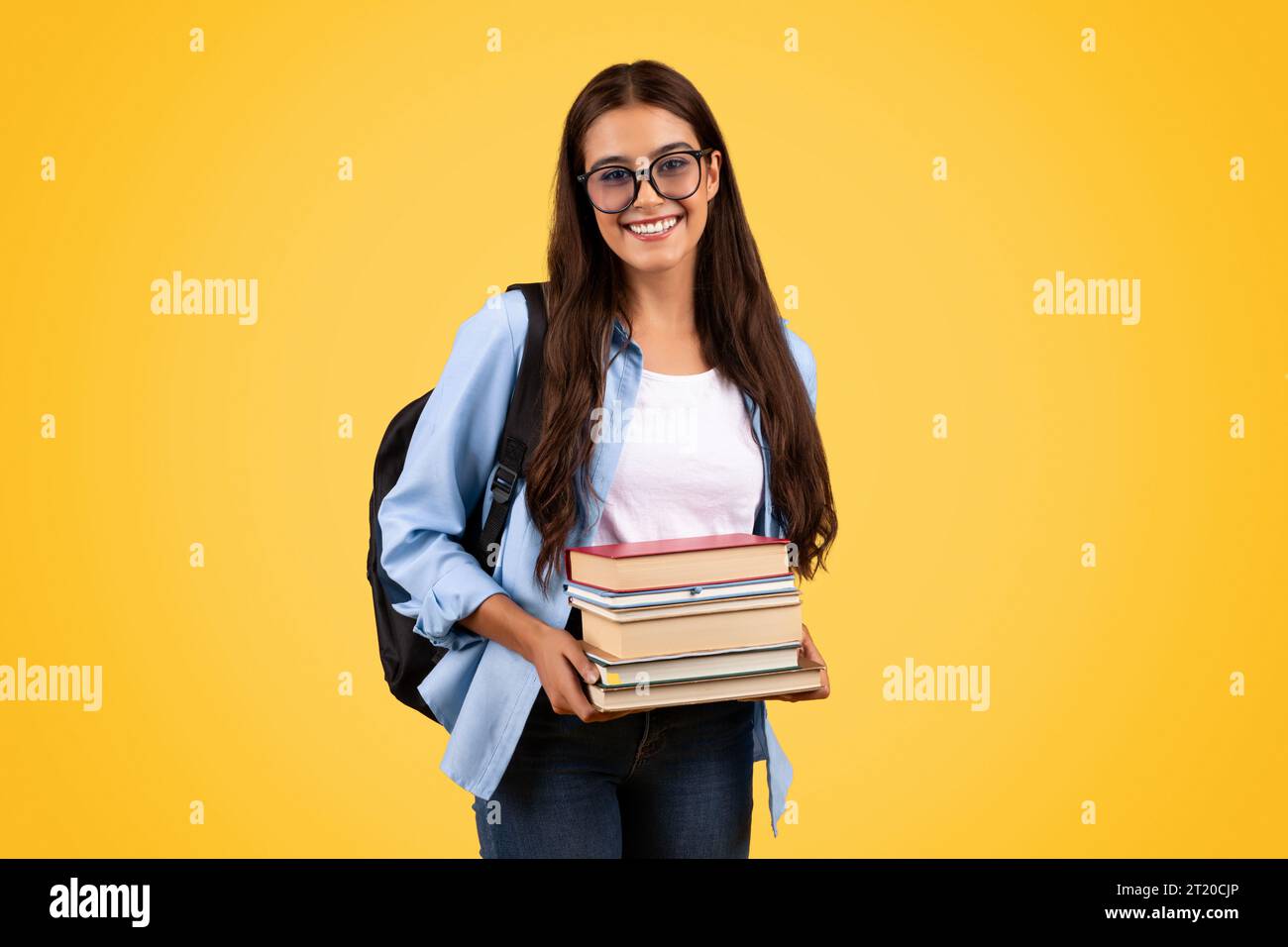 Happy teen student lady with backpack in glasses hold many books, enjoy study Stock Photo - Alamy
