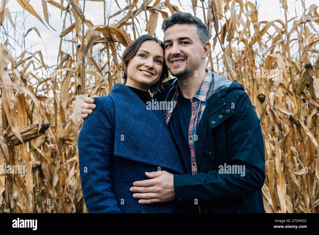 A happy couple in love stands in autumn near a cornfield. A man in a ...