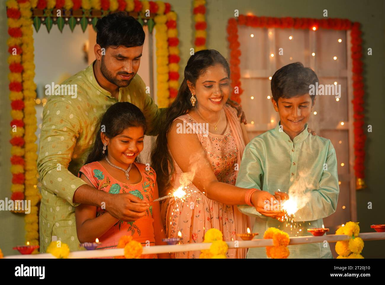 Happy parents with kids playing with diwali sparklers or Crackers by ...