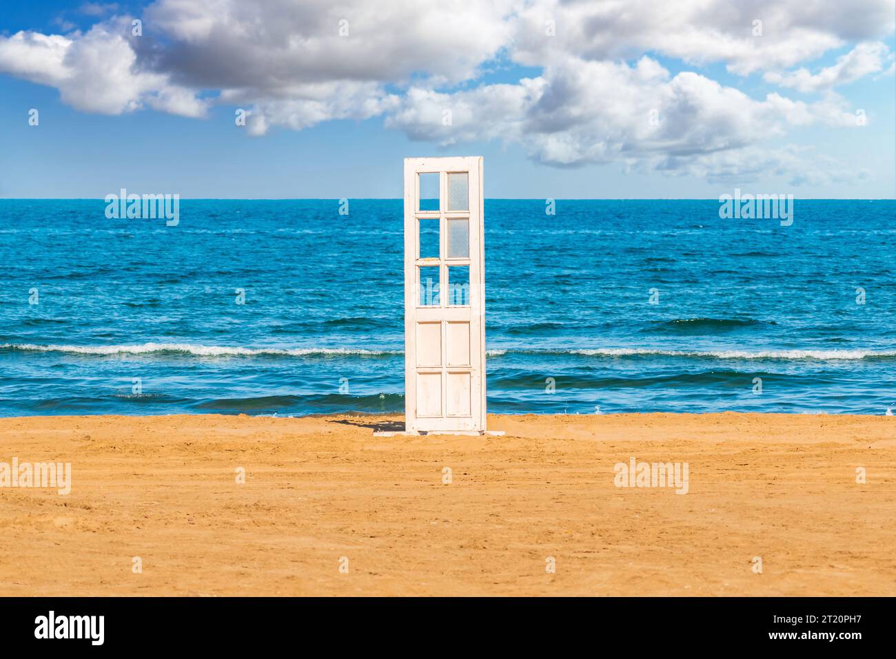 Conceptual photo with a wooden door placed on a beach at the seashore ...