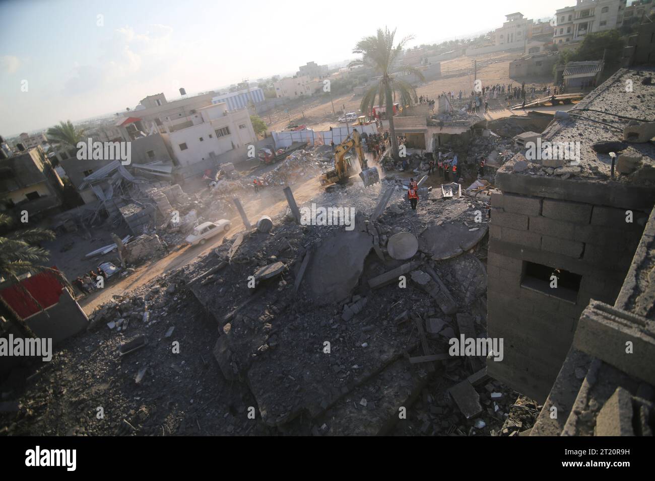 Palestinians clear the rubble of a building destroyed in an Israeli ...