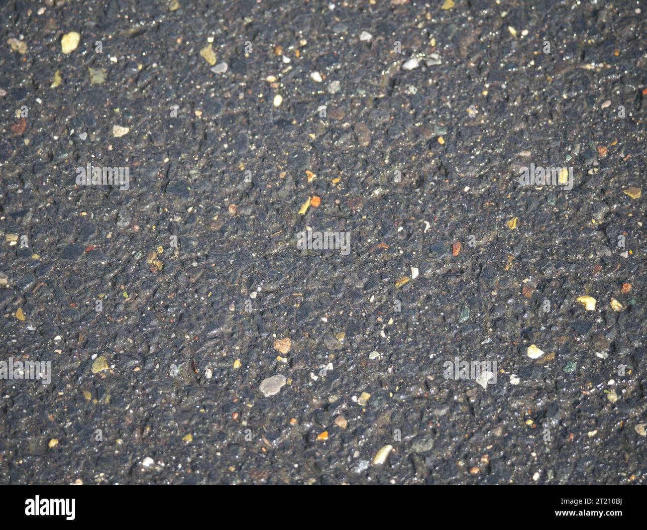 Rain wet surface of tarred pavement in rain with a granular texture ...