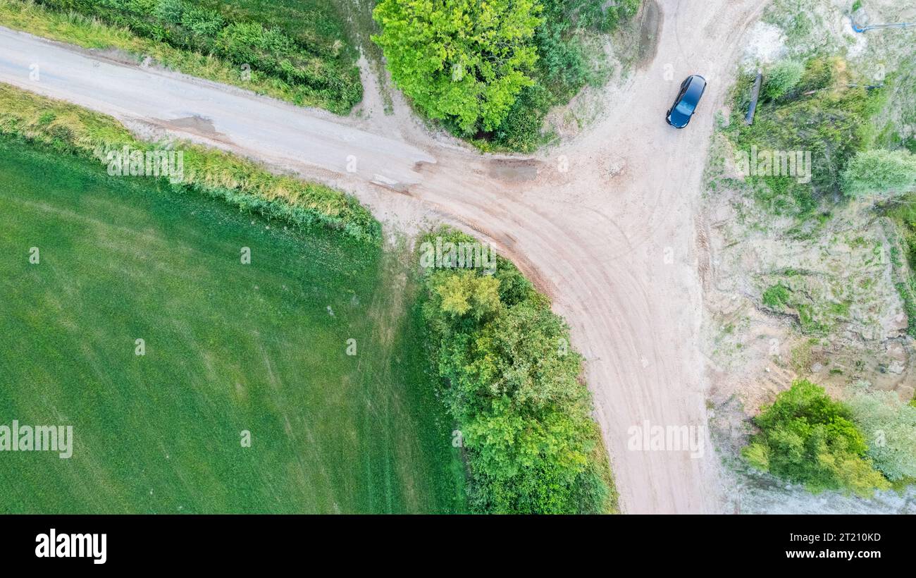 A stunning aerial perspective capturing a black car driving on a ...