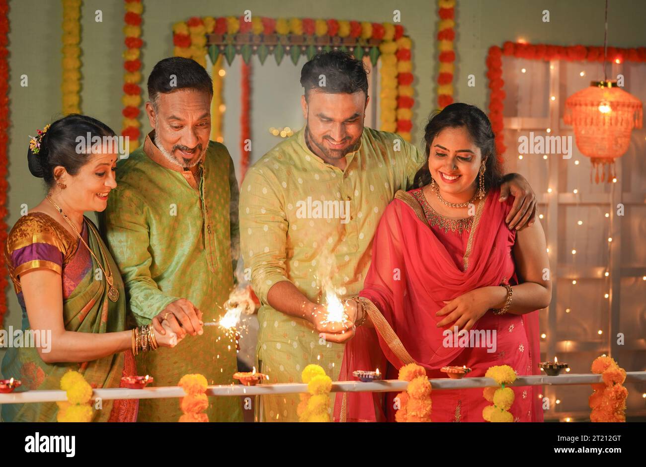 happy Senior parents with son and daughter in law celebrating Diwali ...