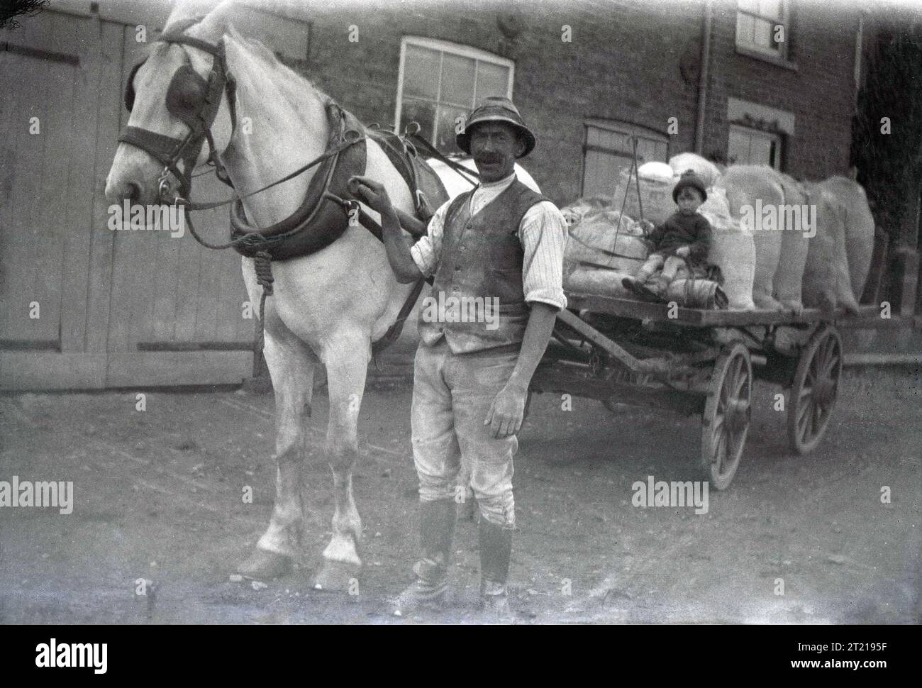 1920s, historical, a farmer standing with his horse & open wooden cart ...