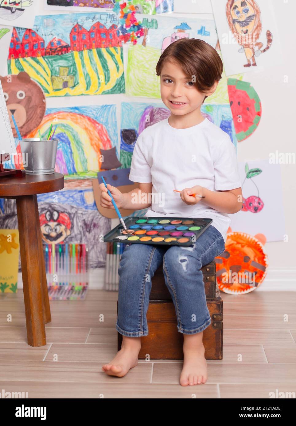 A young child happily painting with a set of watercolor paints Stock ...