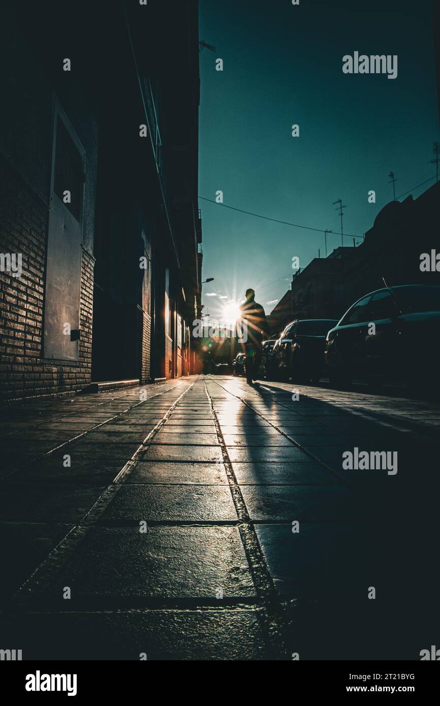 A mature male is standing in solitude beside a vacant building on a ...