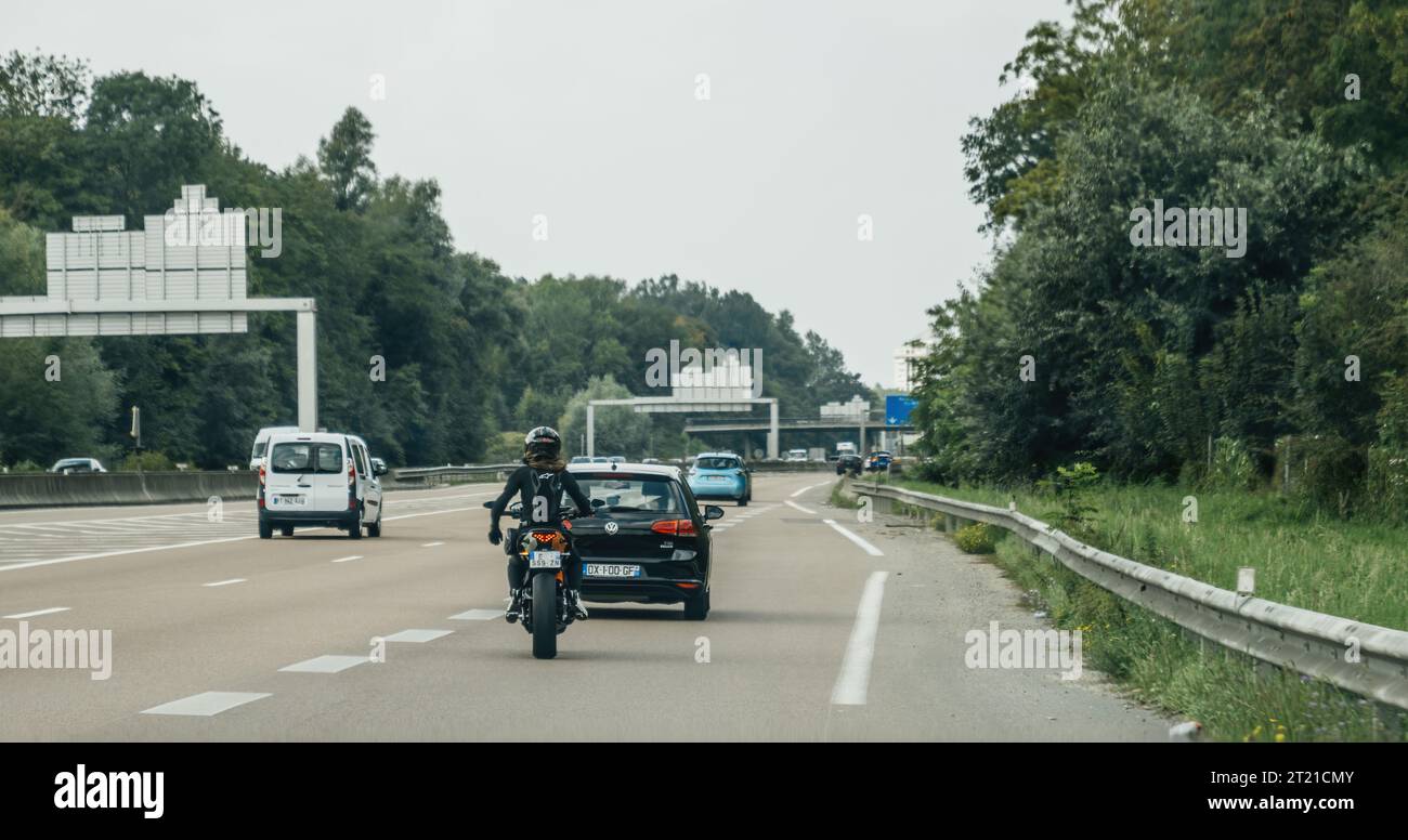 France - Aug 17, 2023: Rear view of a female motorcyclist on a French ...