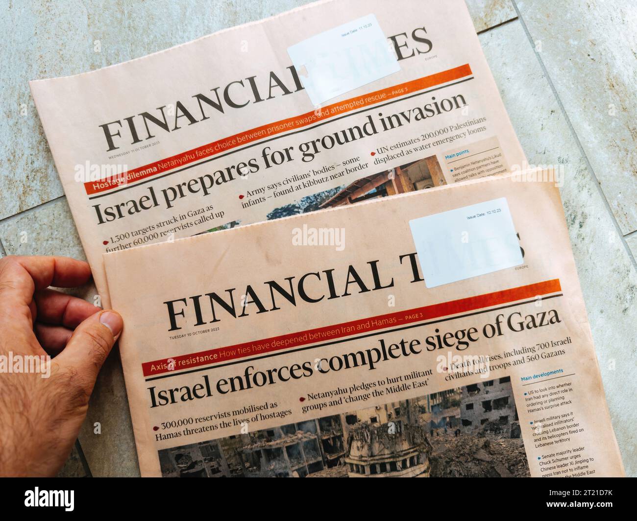 Paris, France - Oct 11, 2023: Male hand holding two editions of ...