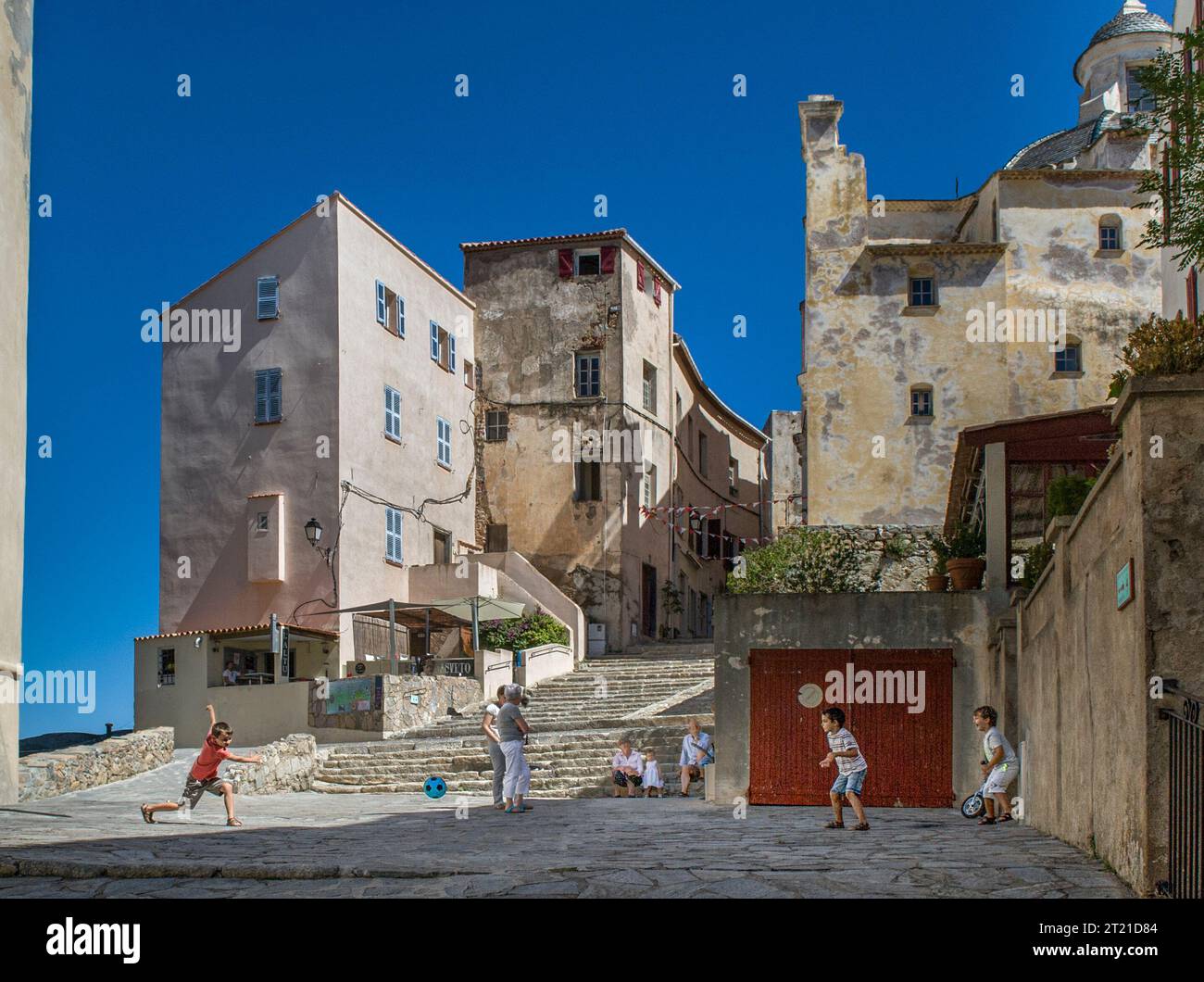 Children playing with a Ball in The Citadel, Calvi while adults look on ...
