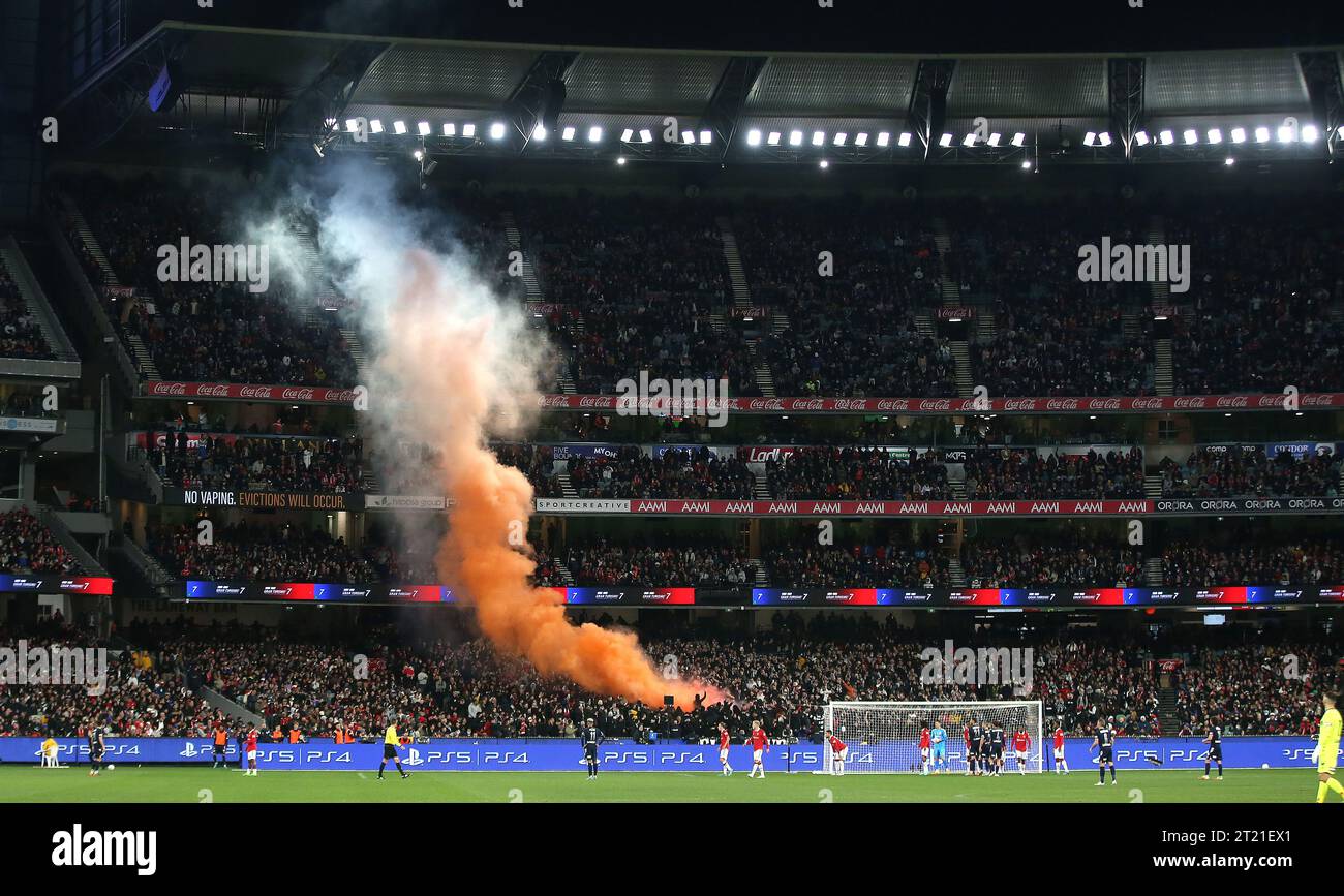Fans let off smoke flares during the match at the MCG Stadium between ...