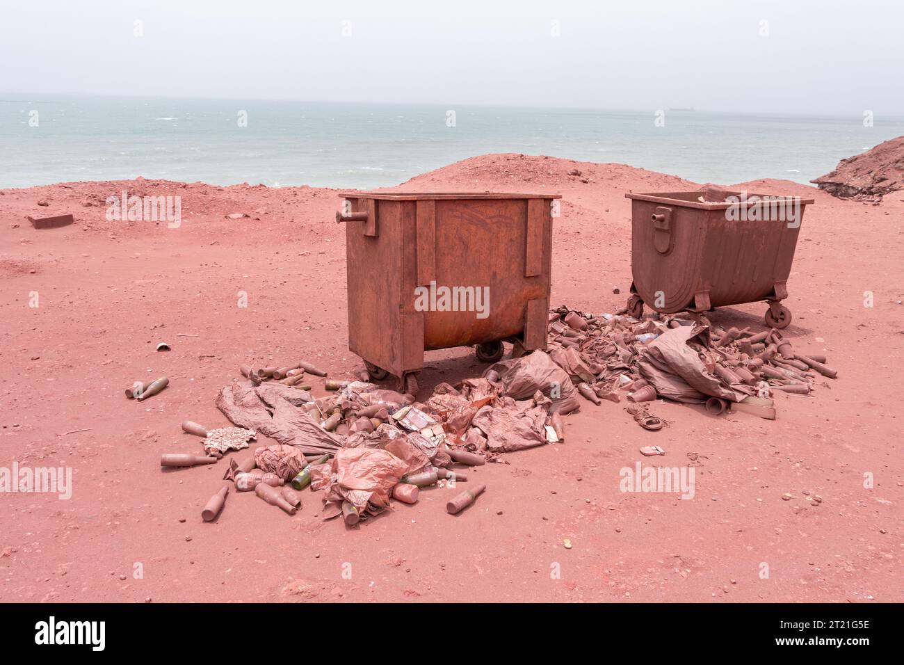 Red beach on the island of Hormuz. Garbage scattered around from the ... Red beach on the island of Hormuz. Garbage scattered around from the ...