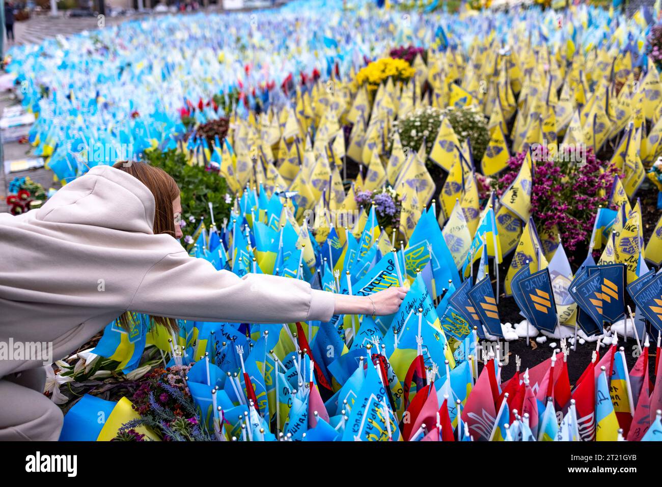 Kyiv, Ukraine. 16th Oct, 2023. A woman puts a Ukrainian flag in ...