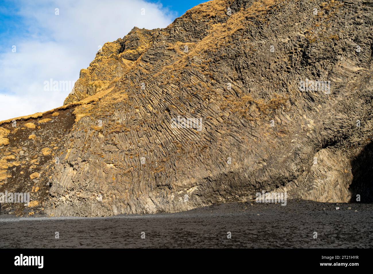 A picturesque view of a basalt cave formation on a black sand beach in ...