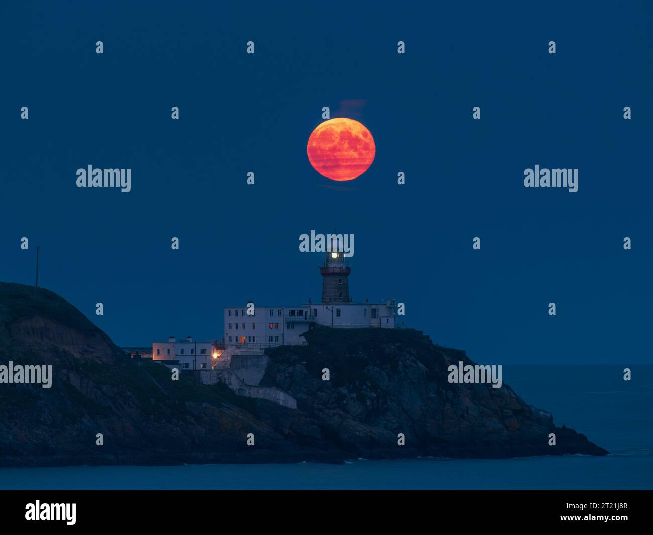 The full harvest moon rising over the Baily Lighthouse Stock Photo - Alamy
