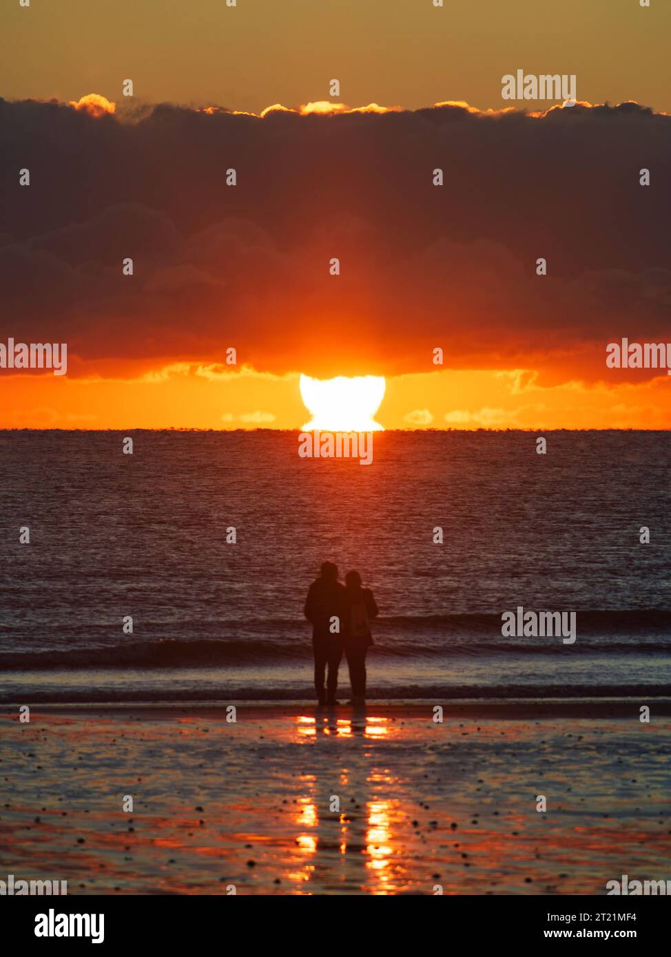 Two early birds taking in the sunrise mirage at Portmarnock Beach on a ...