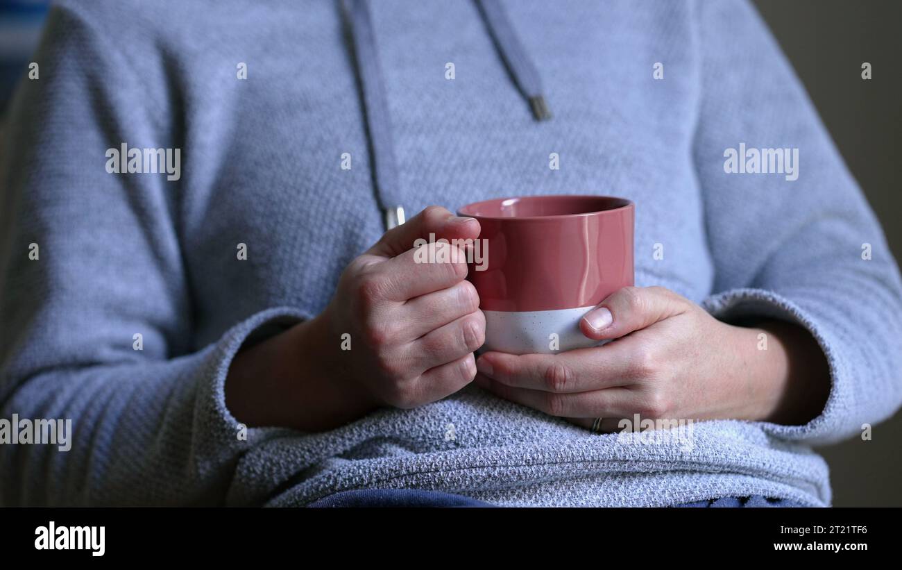 Close-up woman hand holding warm cup of tea or coffee sipping beverage ...