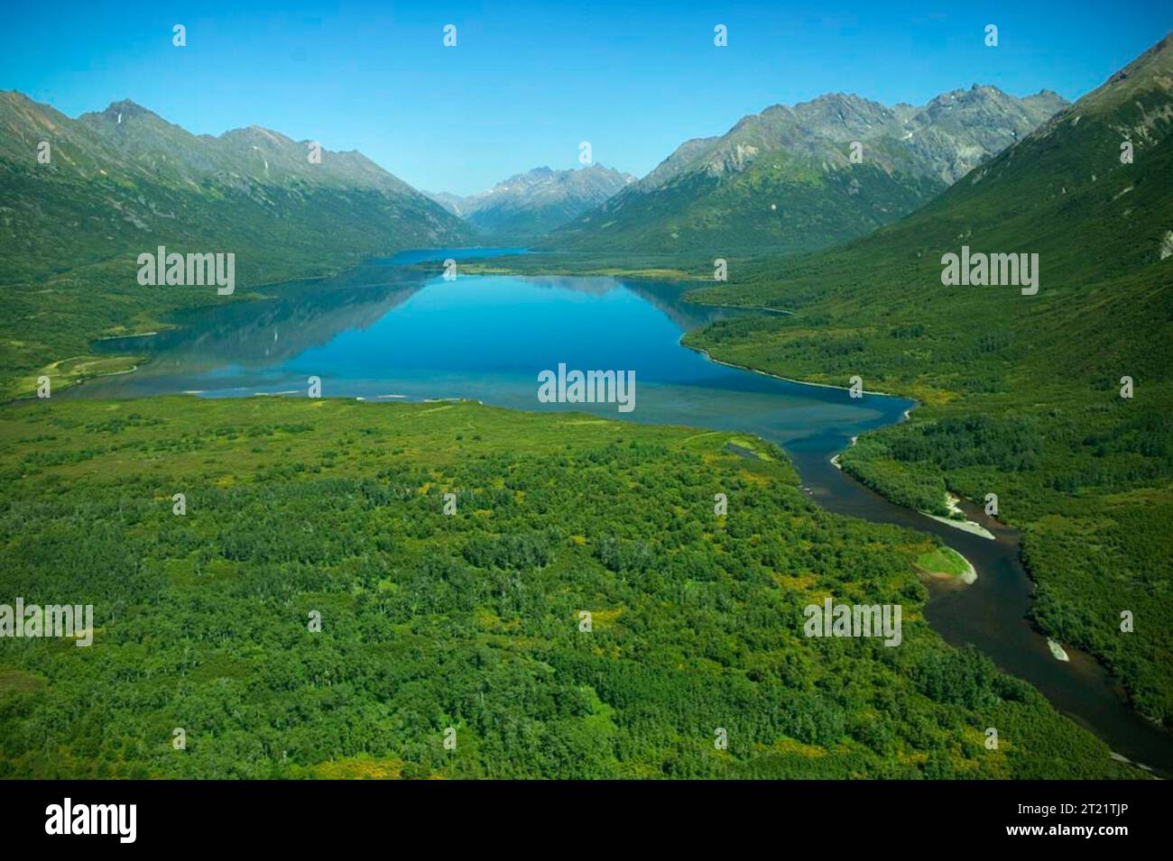 A lake fills the floor of a glacially carved valley surrounded by steep ...