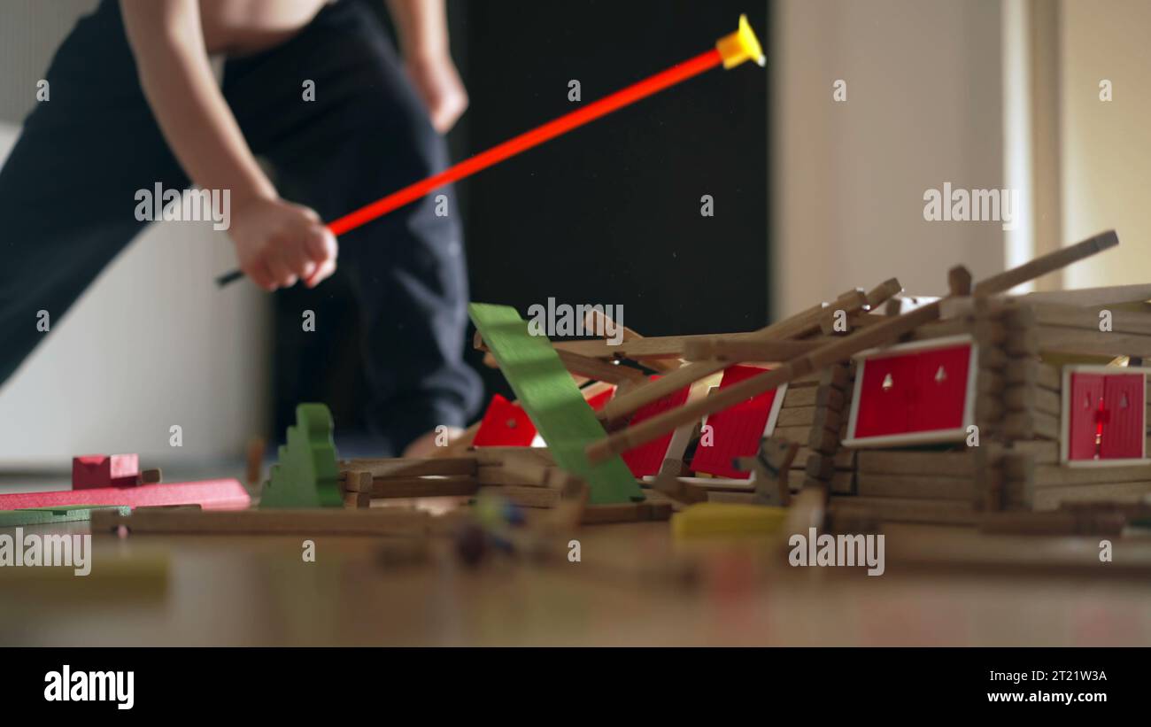 Child destroying house construction miniature. Kid kicking model wood ...