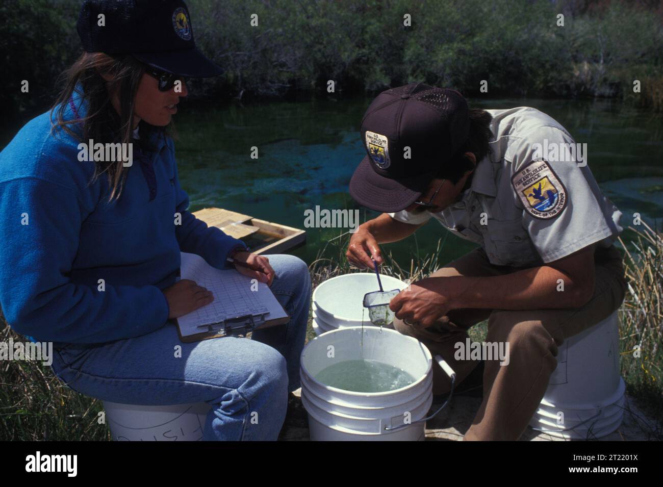 A U.S. Fish and Wildlife Service employee and volunteer work together ...