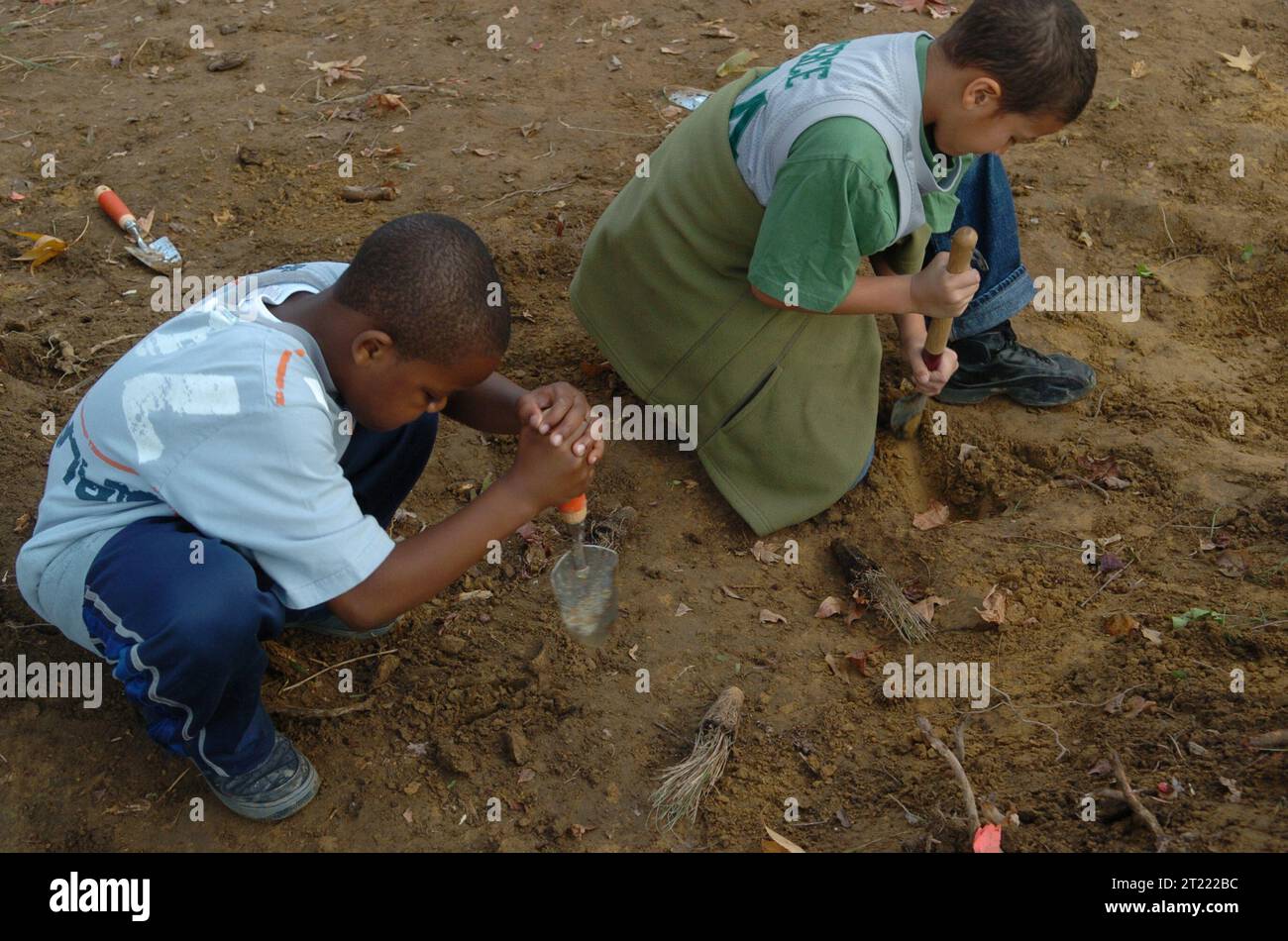 Children dig their holes for planting aquatic plants and grasses in the ...
