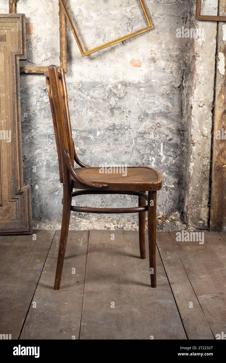 Vintage style . Defective old broken chair in an old dirty room with ...