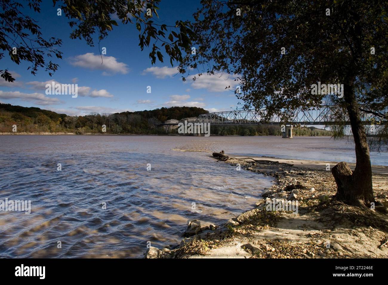 Missouri River shoreline and rippling water with highway bridge in ...