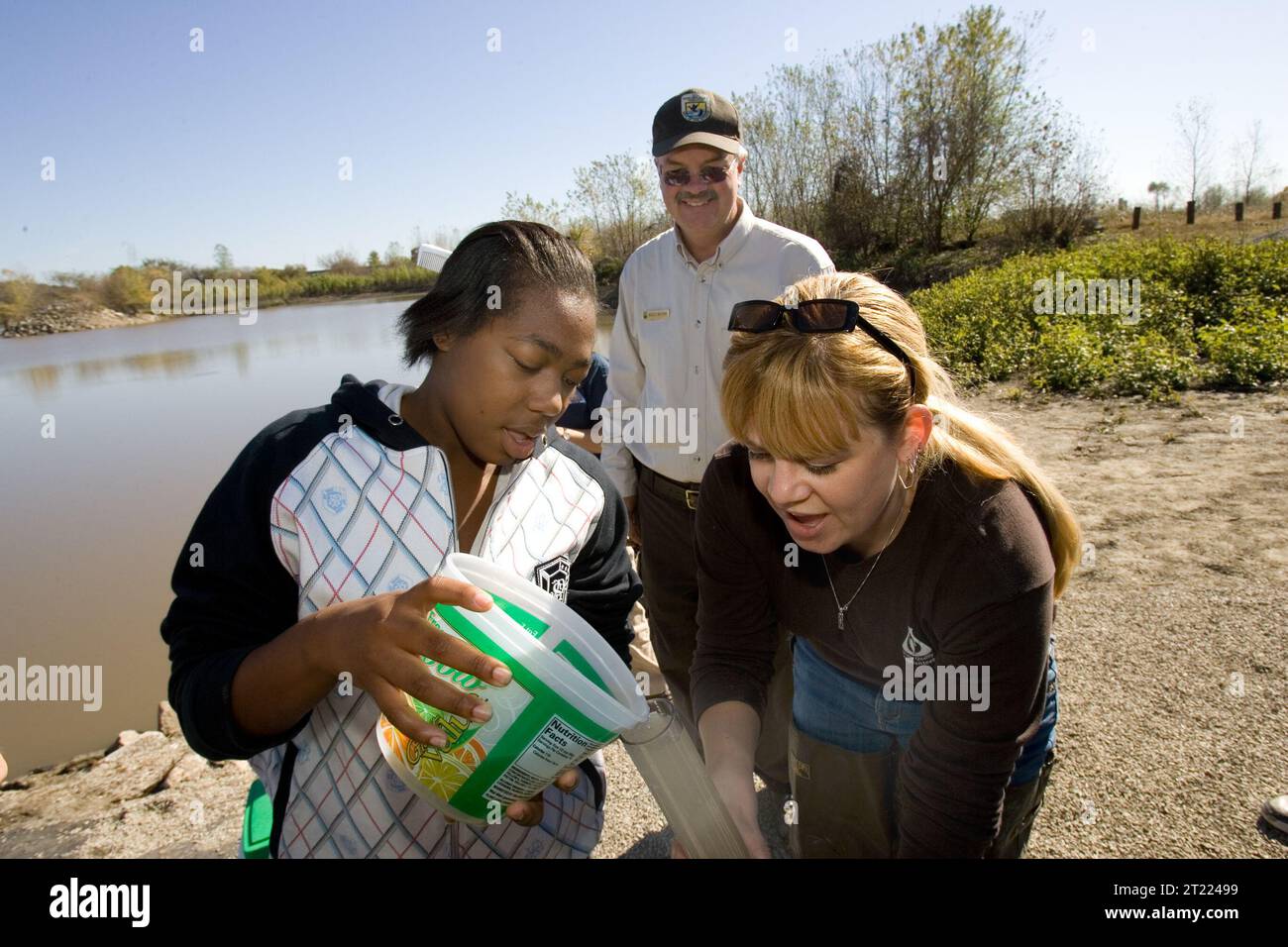 Student pouring Big Muddy river water into beaker held by teacher; U.S ...