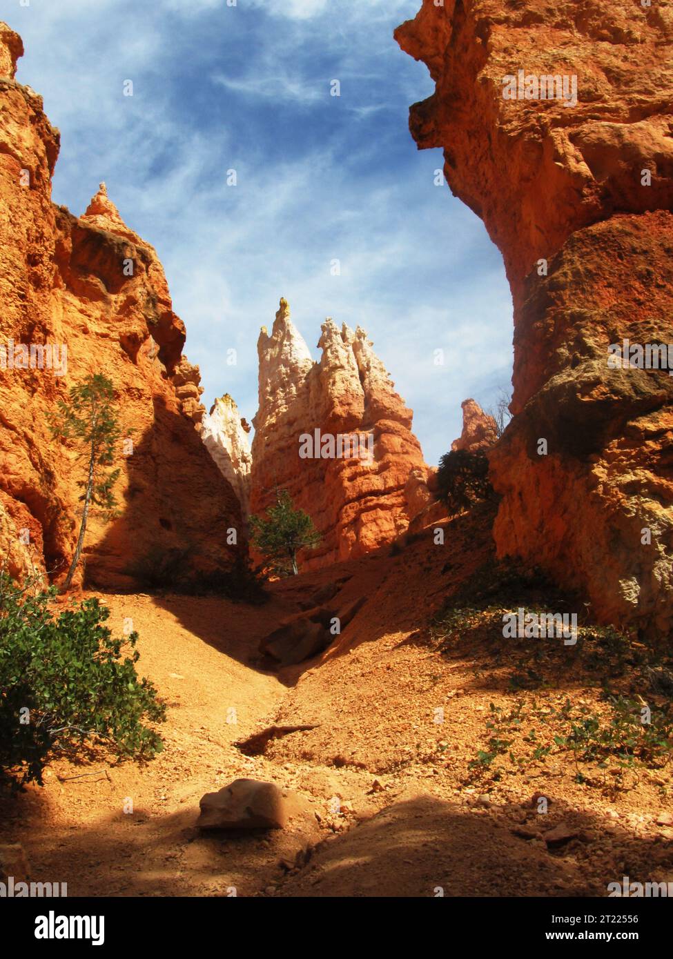 Looking through a gap in the limestone wall at a hoodoo that looks like ...