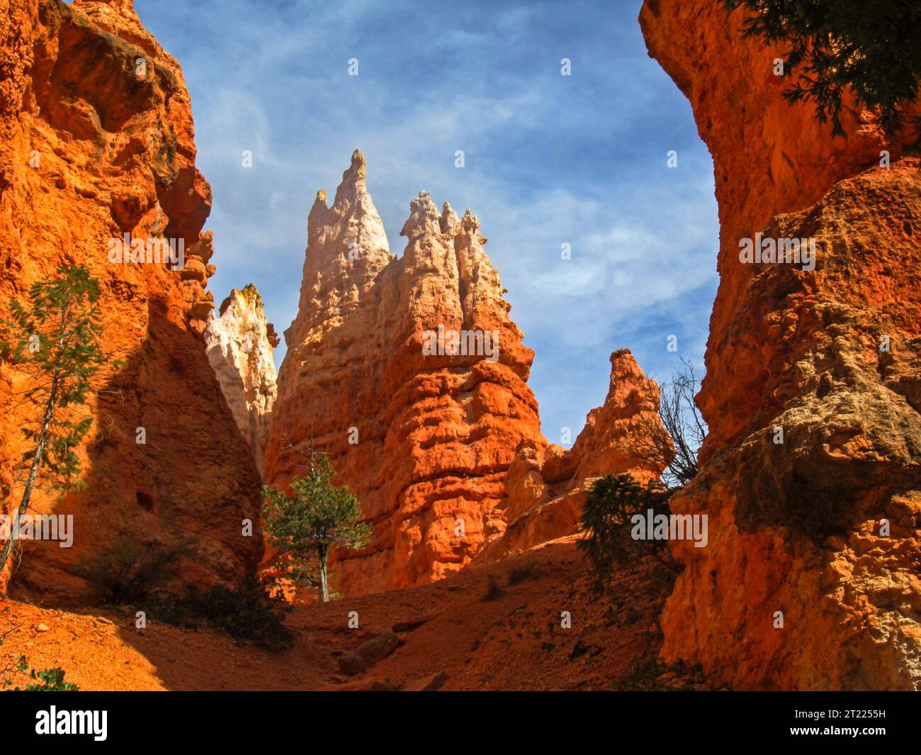 Looking through a gap in the limestone wall at a hoodoo that looks like ...