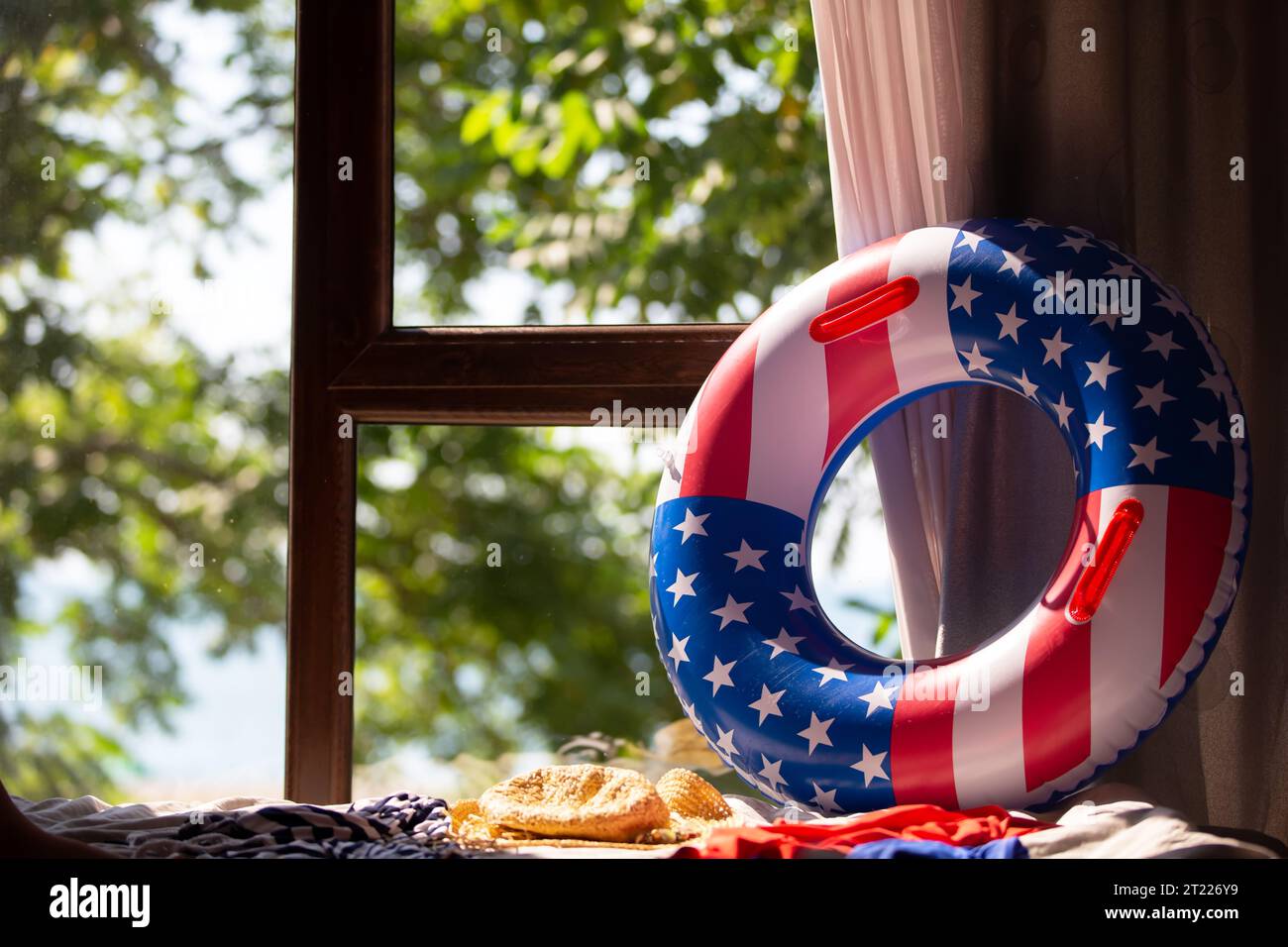 Inflatable swim ring with American flag print on window background ...