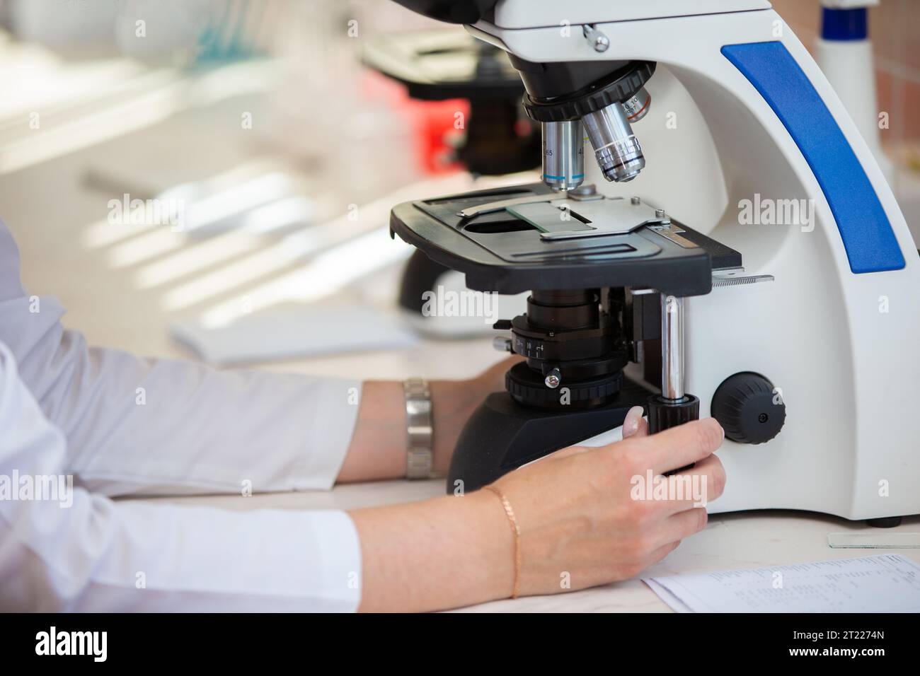 Doctor laboratory worker examines the material under a microscope Stock ...