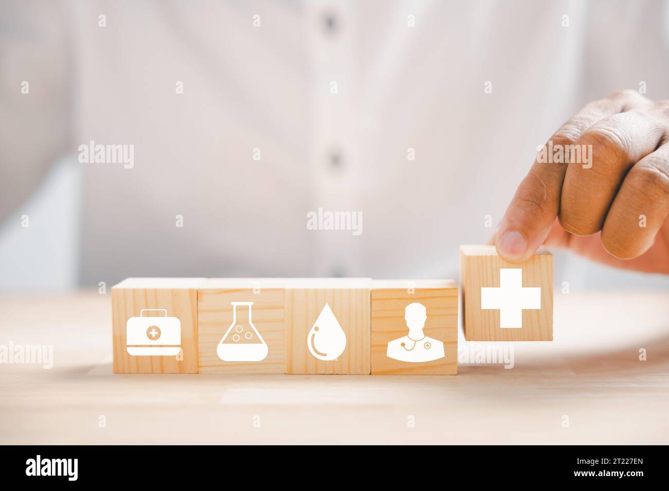 Hand hold wooden block with icon healthcare medical Stock Photo - Alamy
