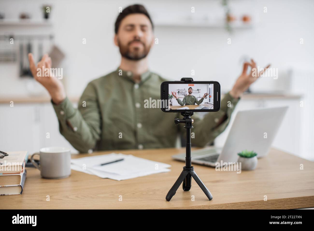 Blurred background of male streamer meditating with closed eyes and ...