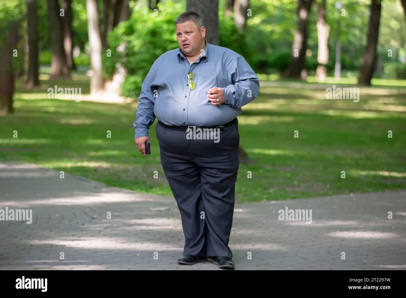 A fat man walks in a summer park.Obesity Stock Photo - Alamy