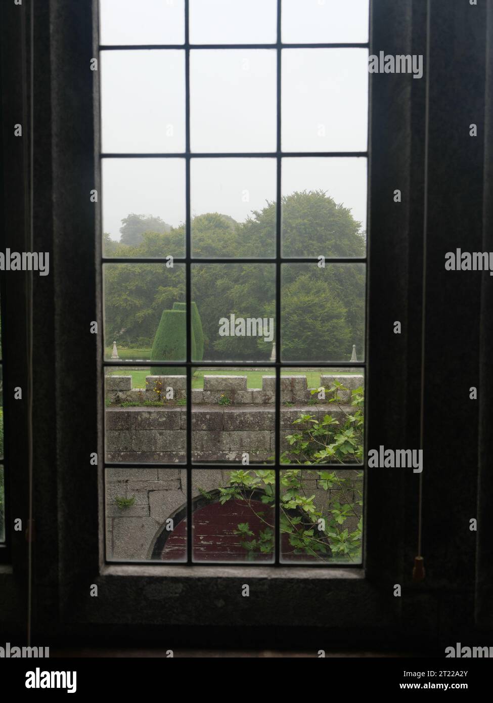 View through a window to the garden of Lanhydrock manor house in ...