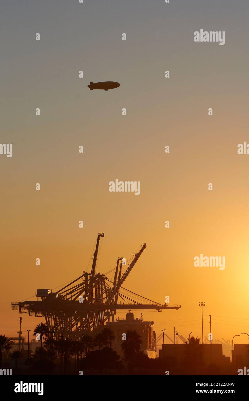The Goodyear Blimp (Dirigible Airship) Flying Over The Long Beach Container Terminal At Sunset ...