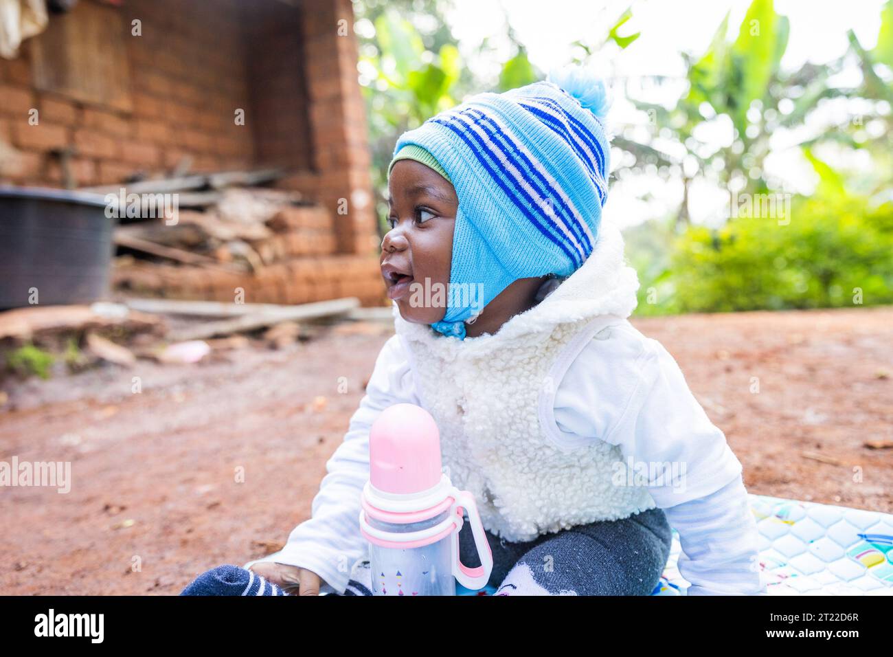 African newborn child sitting on a blanket looks around smiling Stock ...