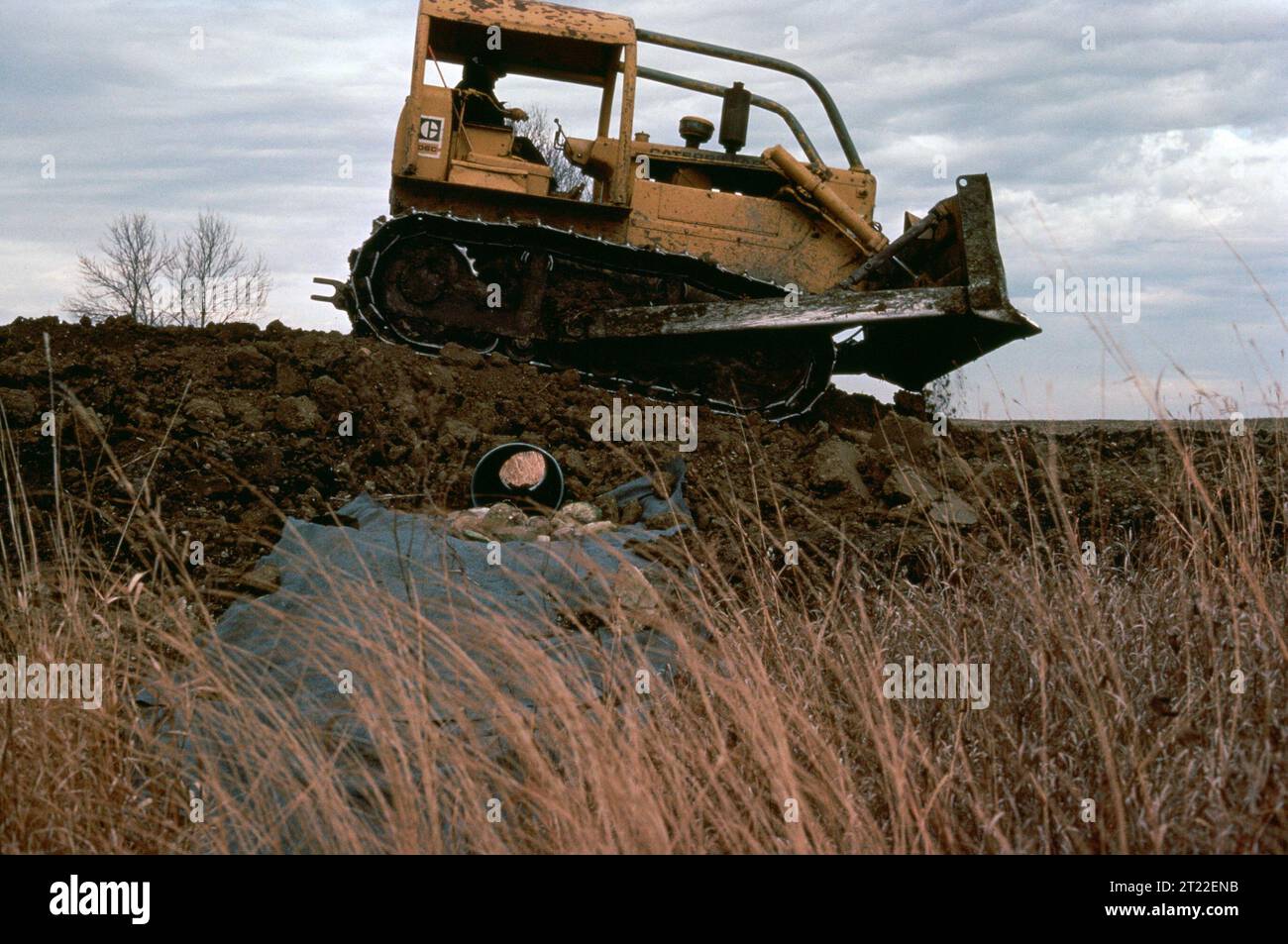 Bulldozer moves soil during a wetland restoration project. Subjects ...
