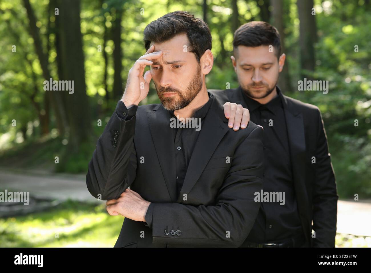 Funeral ceremony. Man comforting his friend outdoors Stock Photo - Alamy