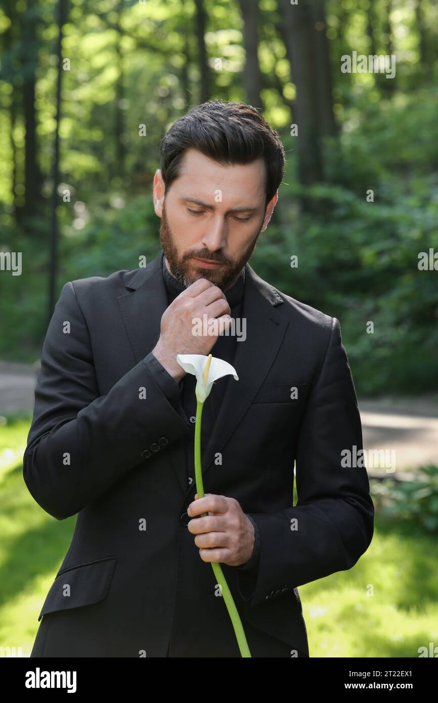Sad man with calla lily flower outdoors. Funeral ceremony Stock Photo ...
