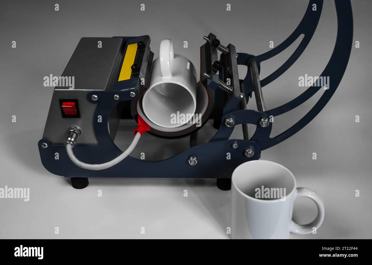 Printing logo. Heat press with cups on white table Stock Photo - Alamy