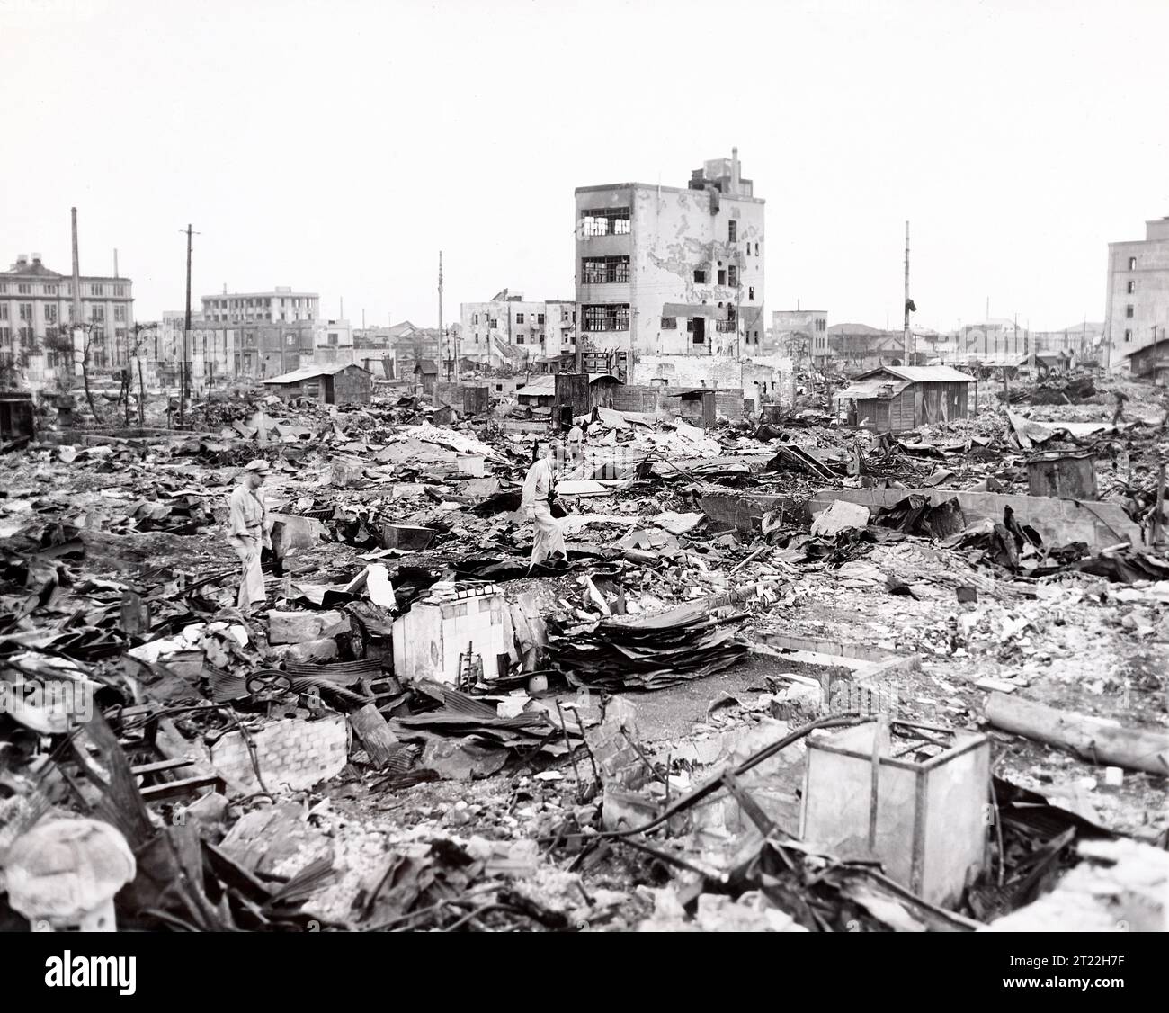 Two men walking among the rubble destroyed by bombs after U.S. Air ...