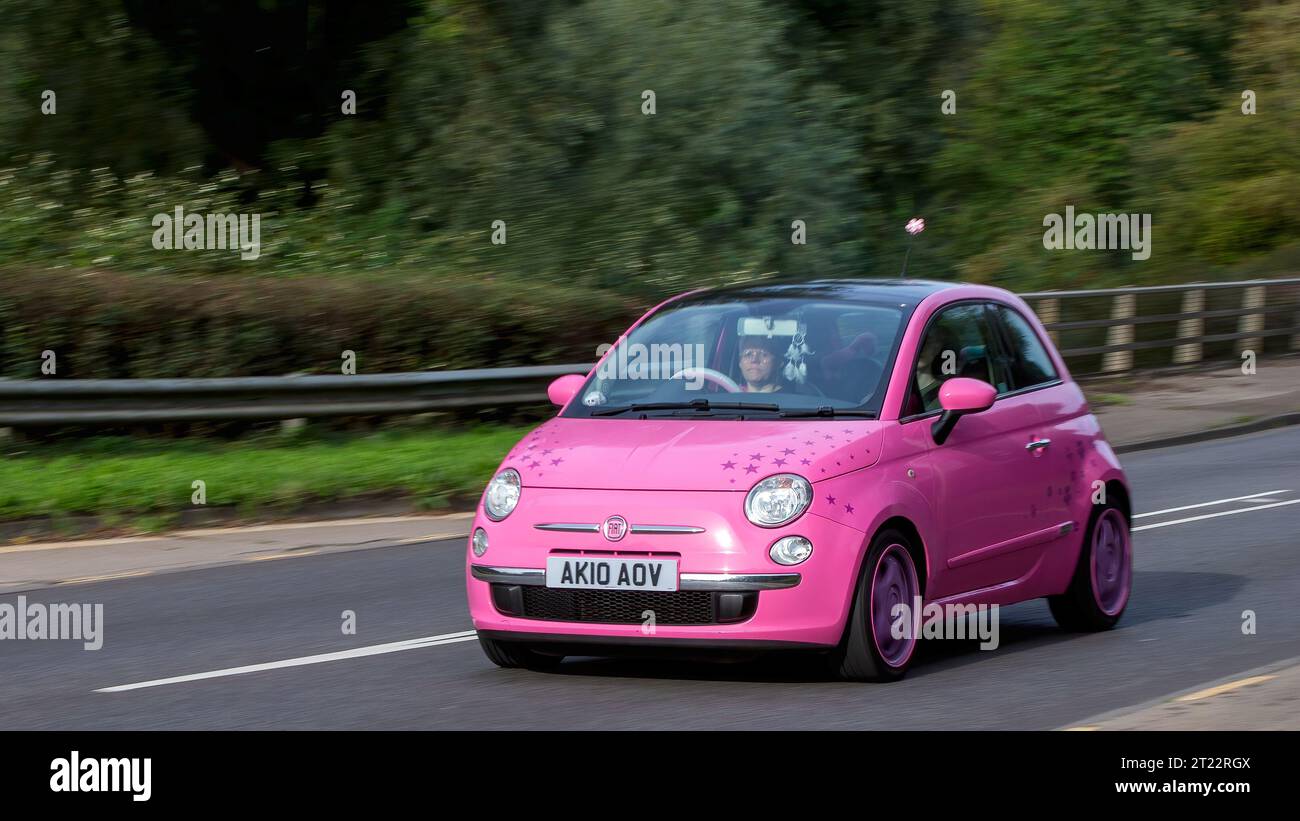 Milton Keynes,UK - Oct 16th 2023: 2010 bright pink Fiat 500 driving on ...