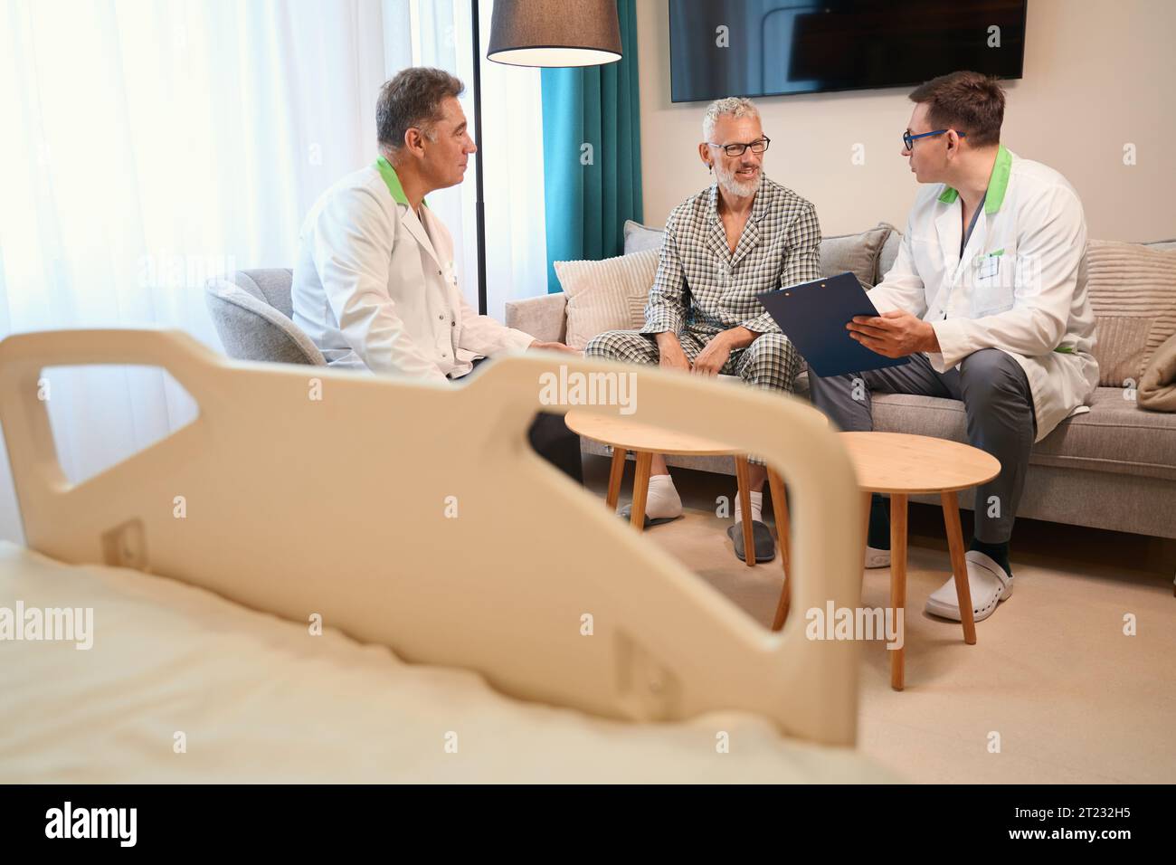 Doctors are questioning old man in comfortable hospital ward Stock ...