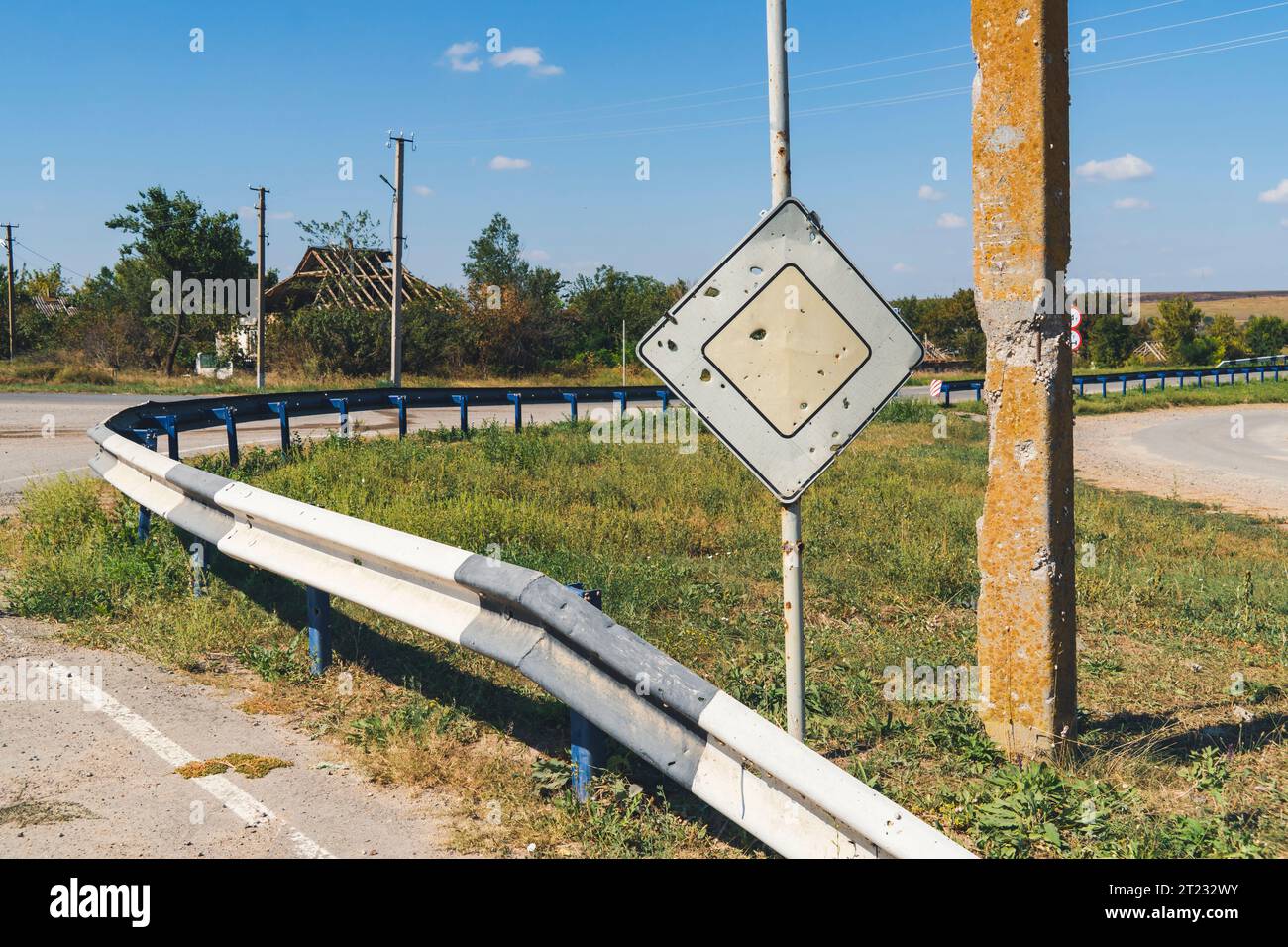 Road sign with bullet holes in a war zone. War in Ukraine. Russian ...