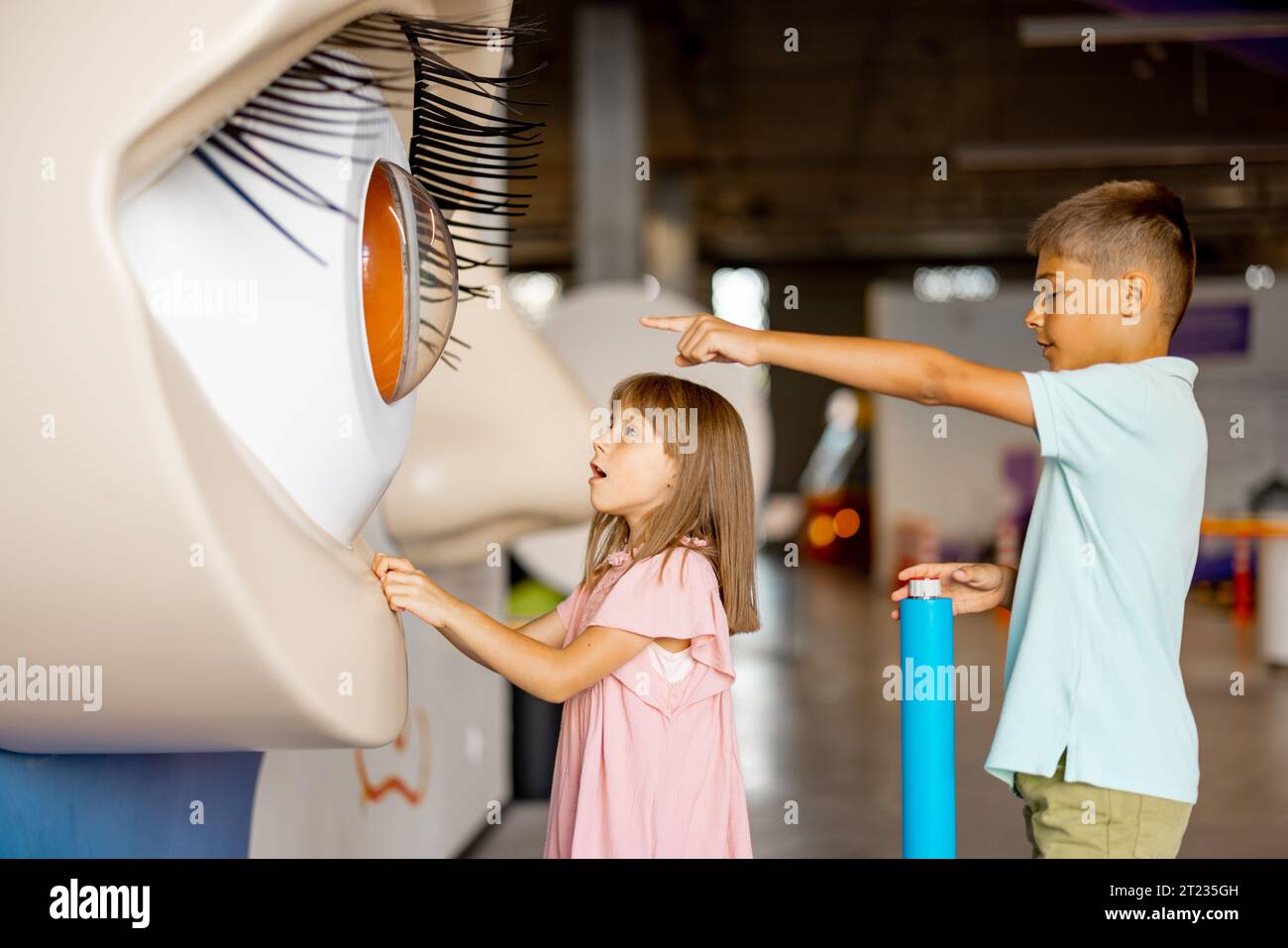 Kids look on a big eye model Stock Photo - Alamy