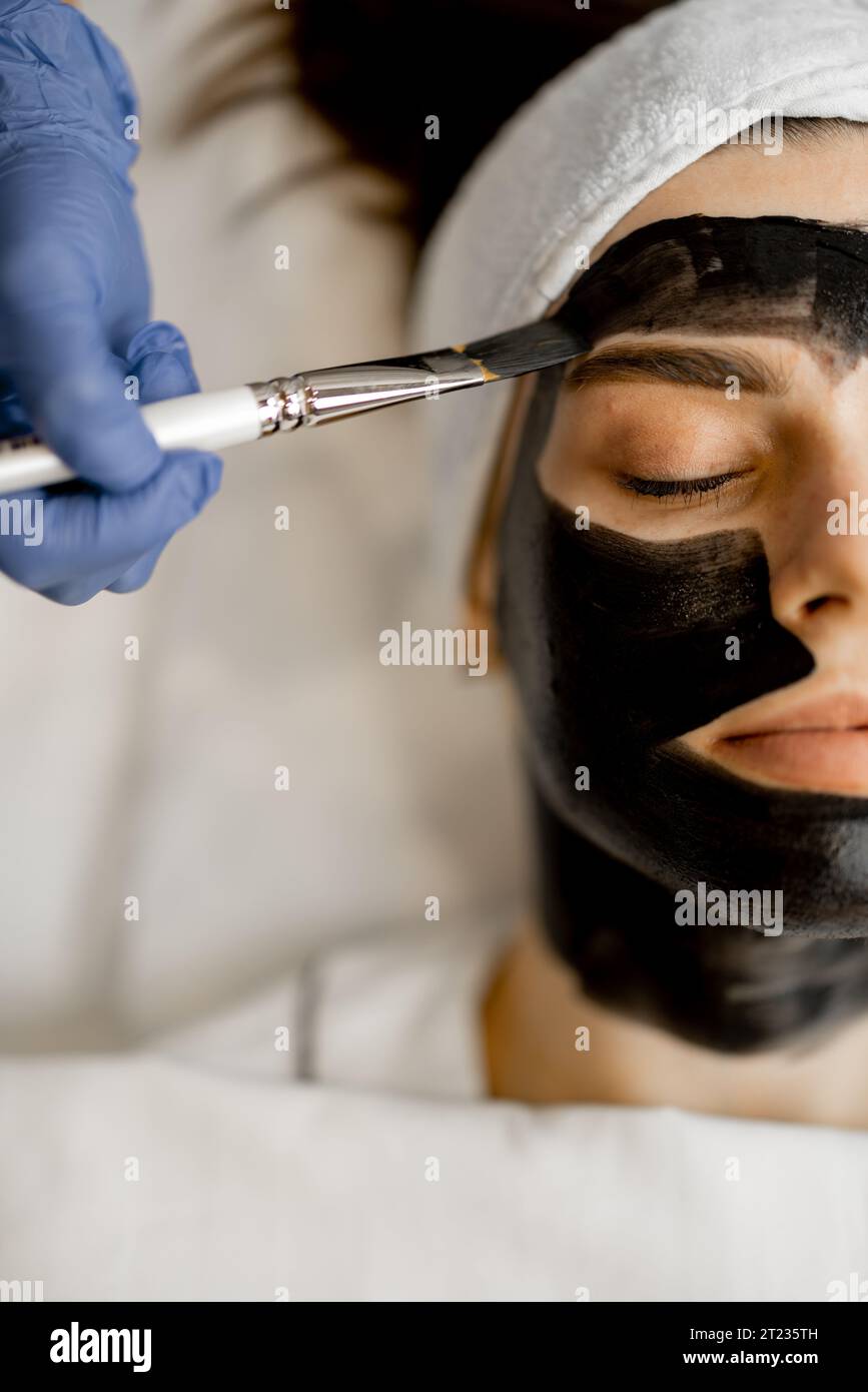 Applying carbon mask to a woman's face Stock Photo - Alamy